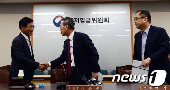 최저임금 의결 마친 뒤 악수나누는 위원장과 부위원장