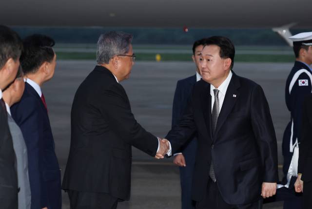 尹대통령 부부 검은 정장 차림 귀국김건희 손엔 바이바이 플라스틱 에코백