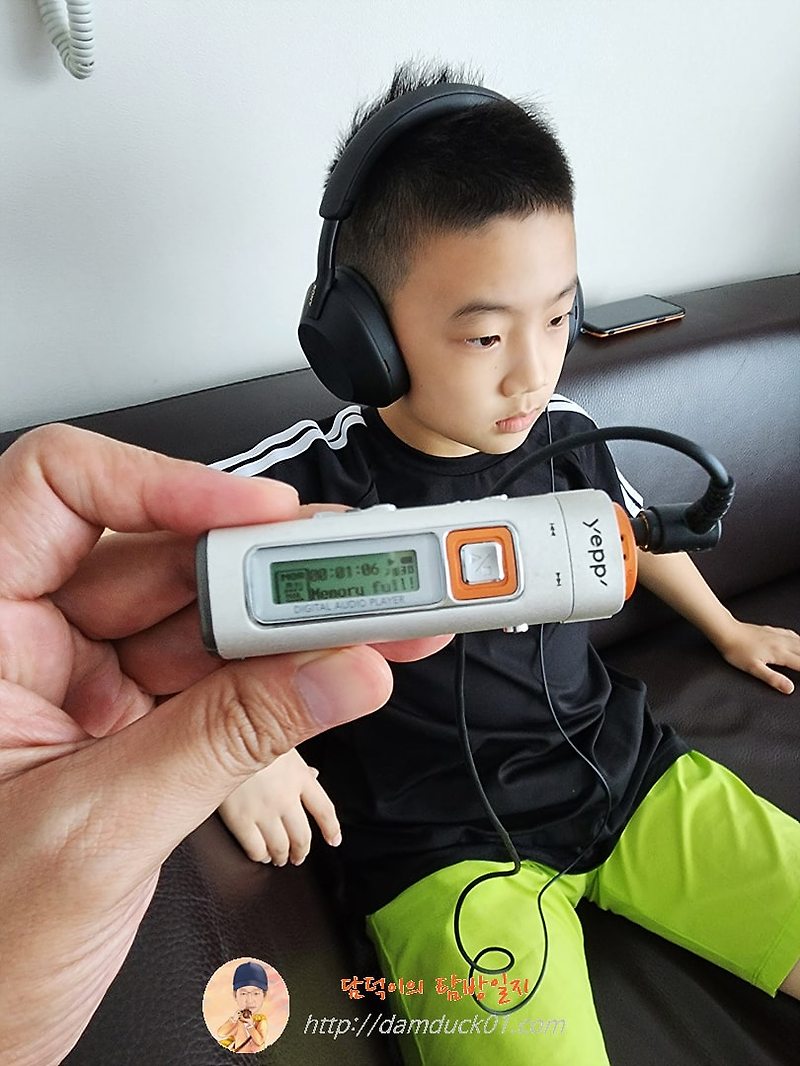 추억의 MP3 플레이어 삼성전자 YEPP YP-55VR (256MB)과 최신 무선 노이즈 캔슬링 헤드폰 WH-1000XM5의 조합.