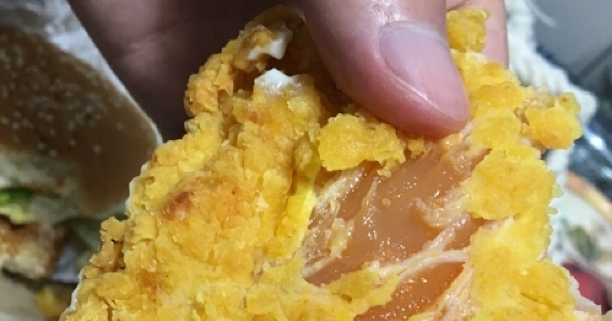 Woman bites into raw chicken burger