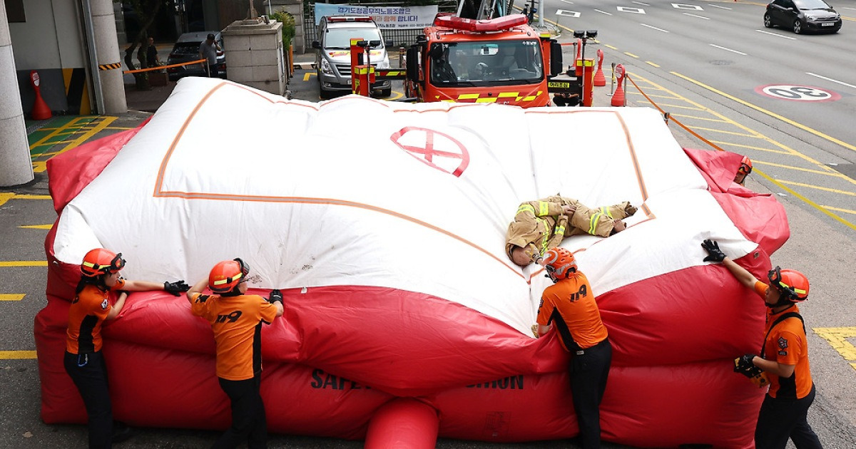Firefighters conduct drills with inflatable rescue mattresses after ...